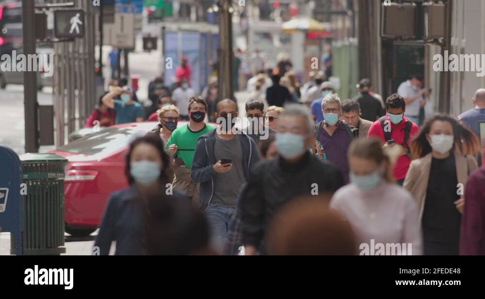 Crowd of people walking street wearing mask masks during coronavirus ...