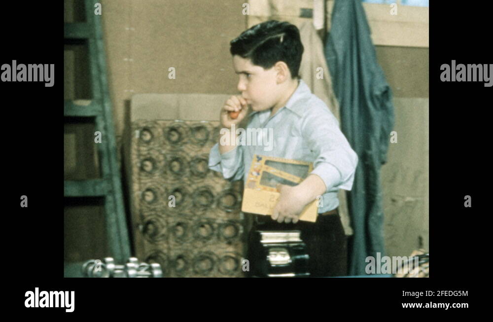 1950s: Boy opens box and blows up balloon. Garage. Girl writes ...