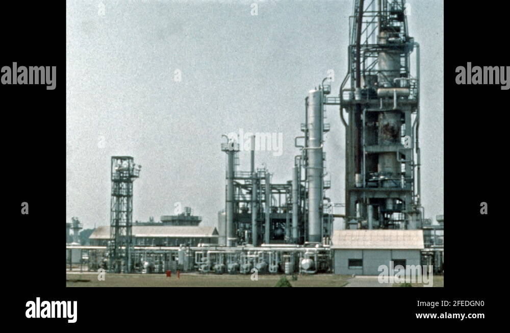 1950s: Pan of nuclear power plant. View of traffic, buildings. Tilt up ...