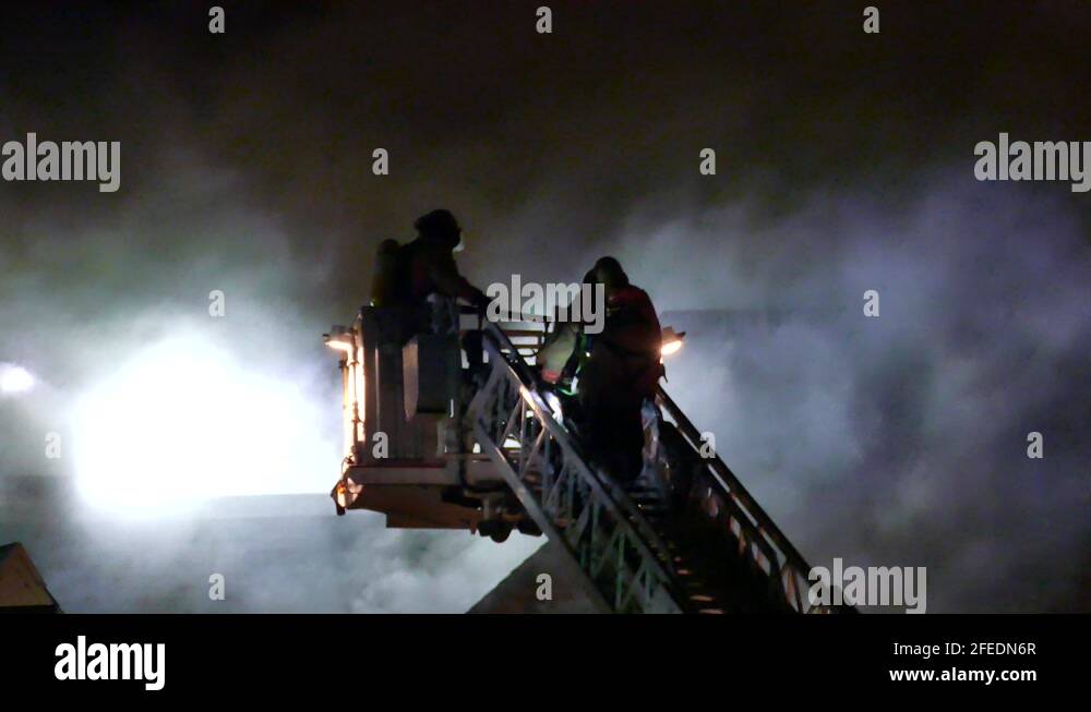 Fireman escalading ladder at night during structure fire Stock Video ...