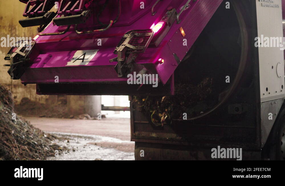 Garbage truck opening its loading hatch for dumping organic waste ...