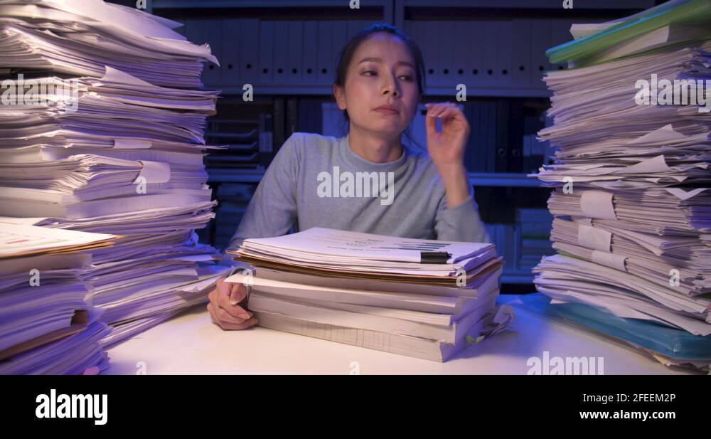 Exhausted asian woman putting documents and lay down on pile of sheets ...