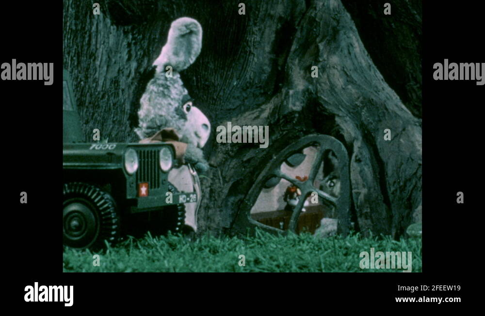 1970s: Puppets. Donkey stands next to Jeep. Mouse comes out of tree ...