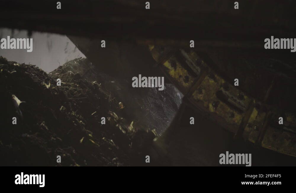 Close up of aing bucket wheel collecting organic waste from a garbage ...