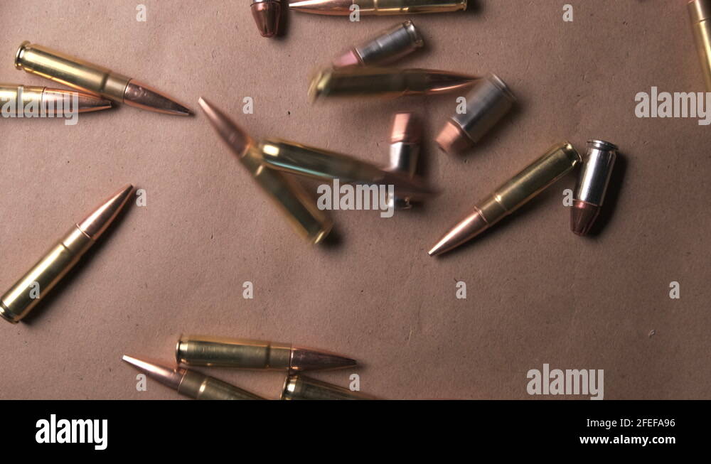 Slow motion footage of rifle shells and pistol bullets falling onto ...