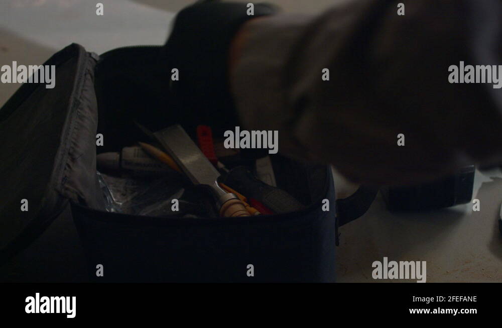 grabbing tools out of a tool box or pouch in order to work on a broken ...