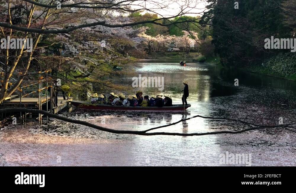 Tourists riding on a traditional Japanese rowing boat wearing Japanese ...