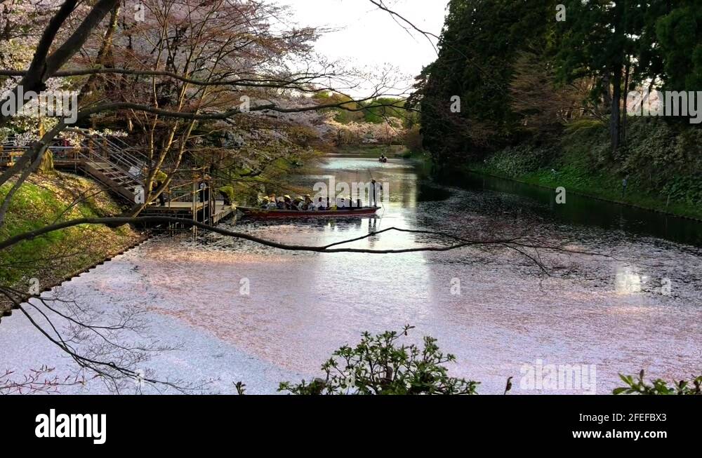 Tourists riding on a traditional Japanese rowing boat wearing Japanese ...