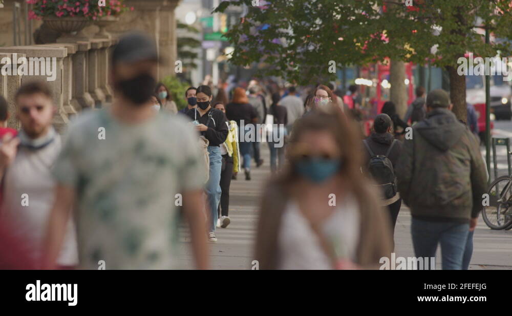 Crowd of people walking street wearing mask masks during coronavirus ...