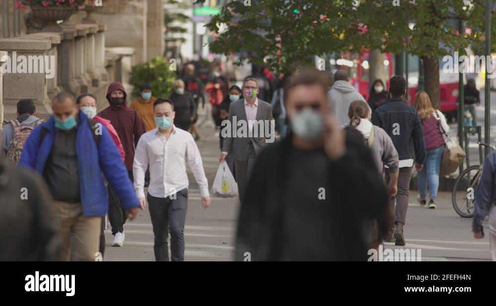 Crowd of people walking street wearing mask masks during coronavirus ...