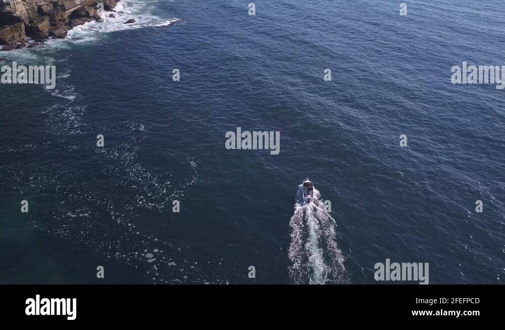 Top down overhead flyover a single speed fishing boat on the ocean at ...