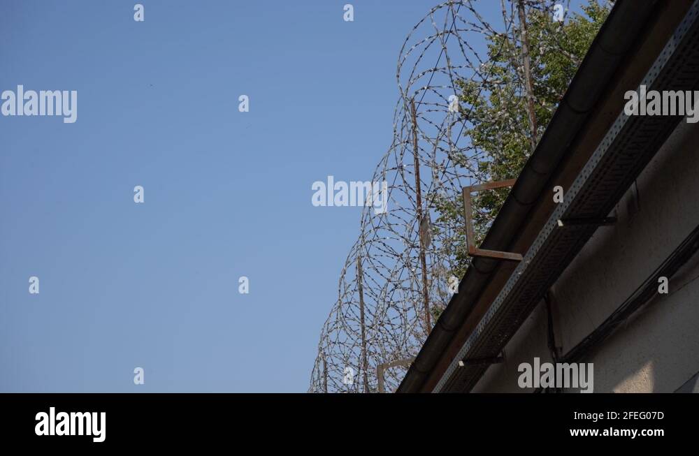 Coils of Barbed Wire on Top of a Fence. Jail Cells. Prison Interior ...