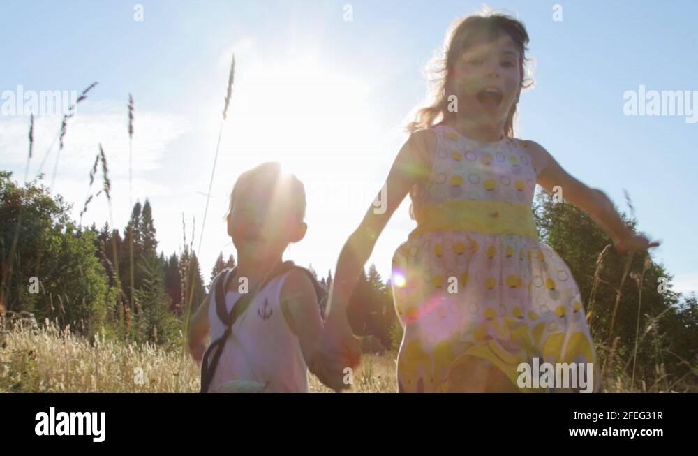 Two little girls running through summer field Stock Video Footage - Alamy