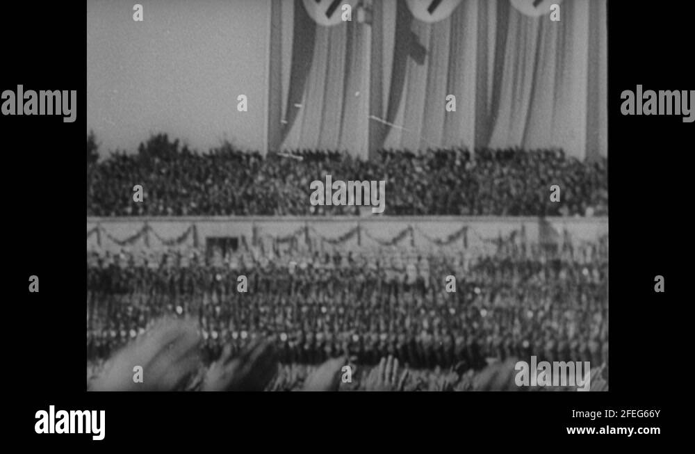 1940s EUROPE: Swastika. Hitler. Nazi rally. Hitler gestures and shakes ...