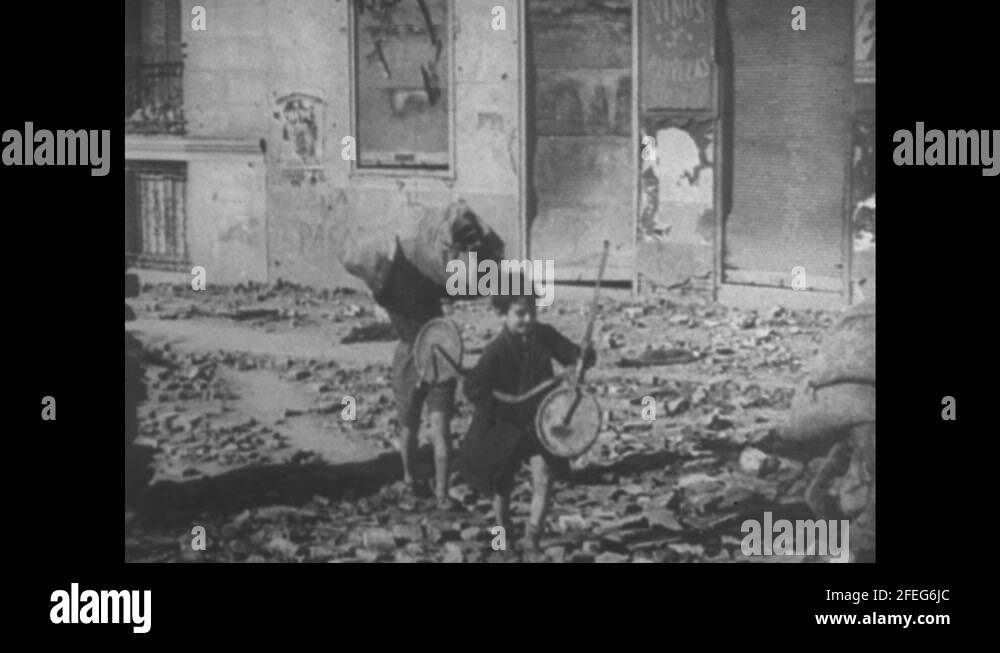 1940s: People lift dead body of child. Man runs holding person. Two ...