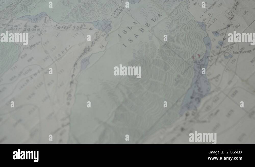 A detailed map of Isabela island of the Galapagos islands is on a table ...