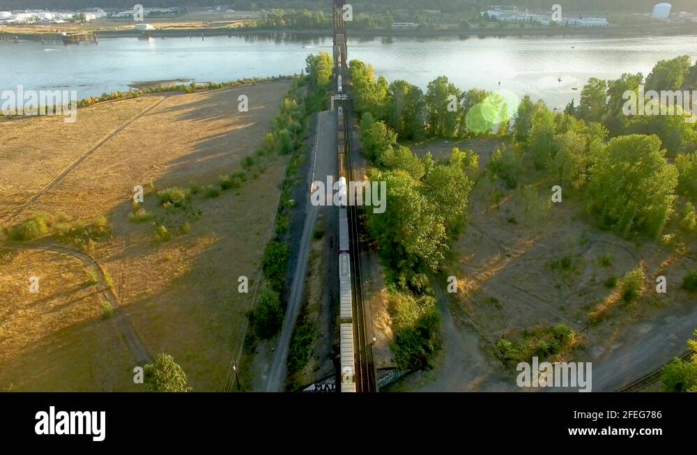 Birds eye view of long freight train running on the track and crossing ...