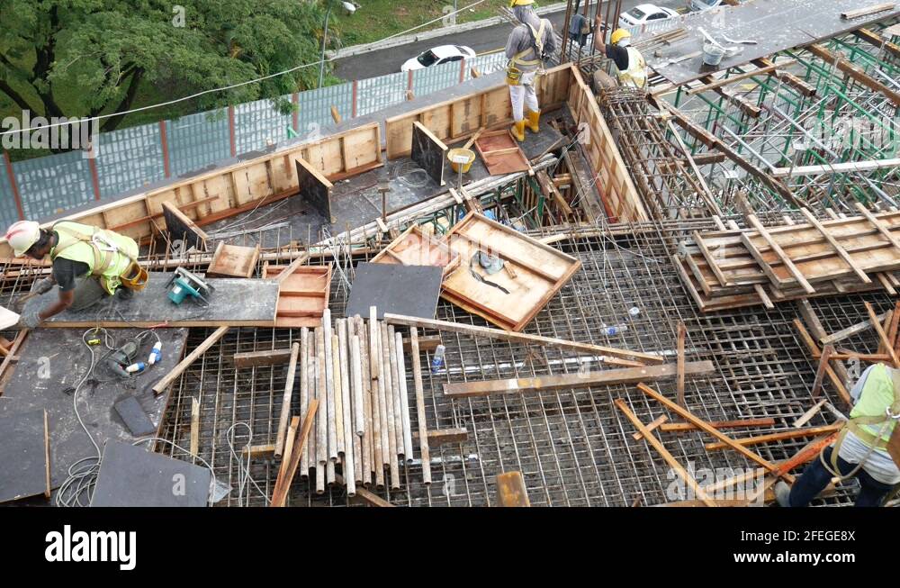 Construction workers fabricating steel reinforcement bar & timber ...