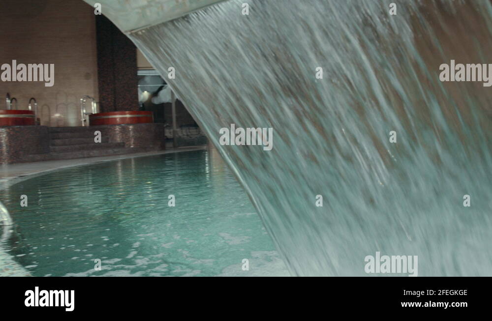 Waterfall jet in swimming pool. Fountain for hydromassage in luxury ...