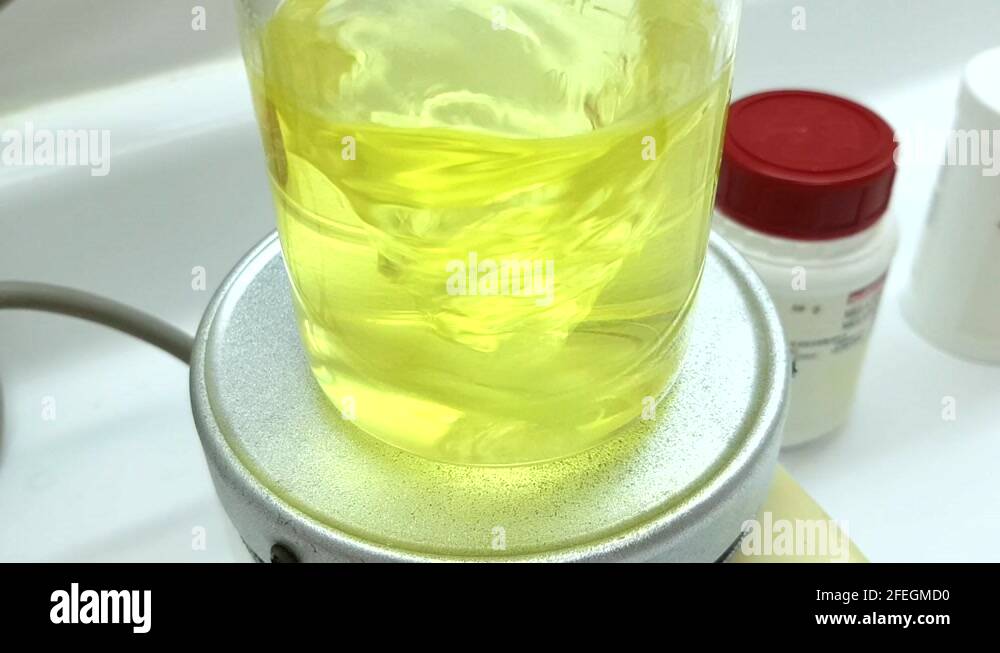 magnetic stirrer mixing yellow chemical solution in beaker Stock Video ...
