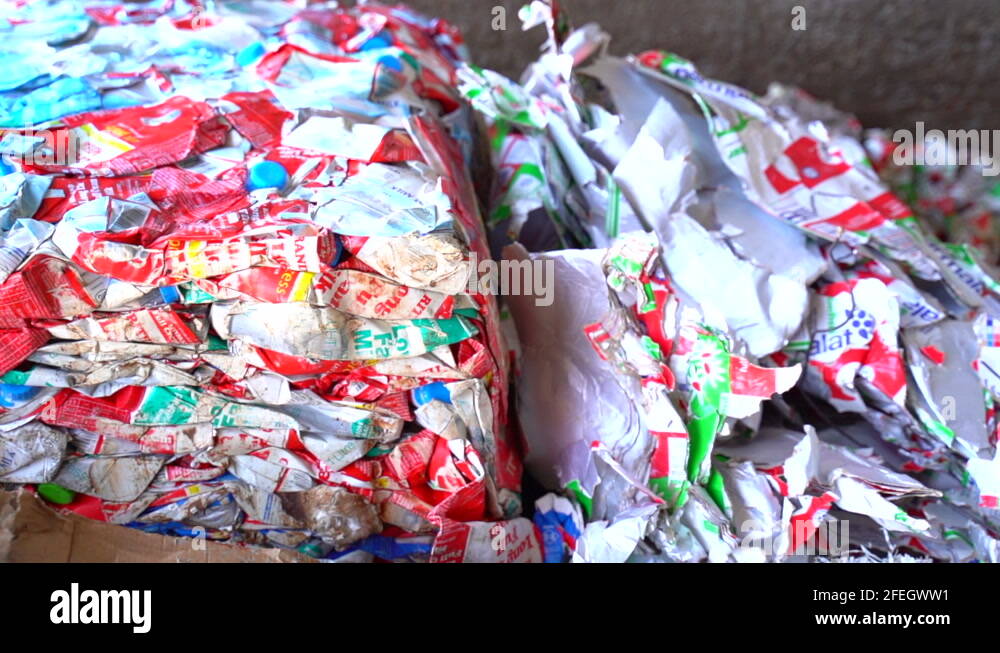 cinematic shot of flattened milk cartons ready to be recycled sill in ...