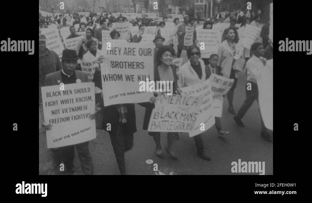 1960s: Title placard. Men and women carry signs in protest march ...