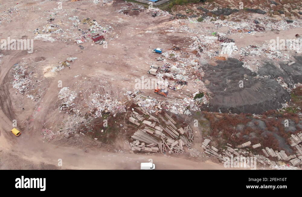 Garbage dump. Bulldozer is pushing debris on field. Construction waste ...