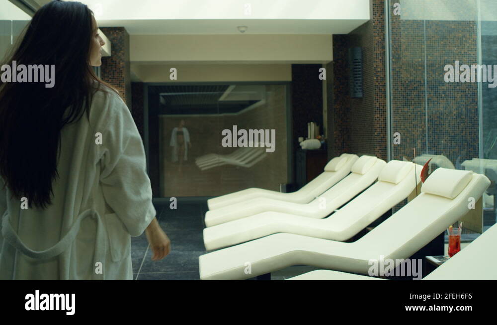 Sexy woman taking off bathrobe in spa center. Pretty girl relaxing on ...