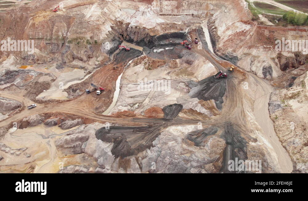 Deep huge mining quarry with huge mounds of minerals. Excavators are ...