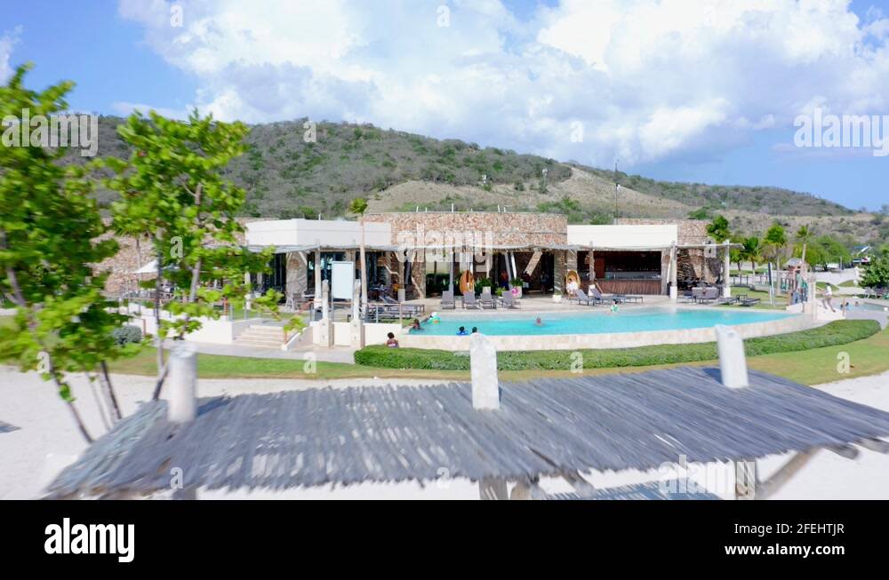 Tourists relax in swimming pool of Puntarena Bani beach resort. Aerial ...