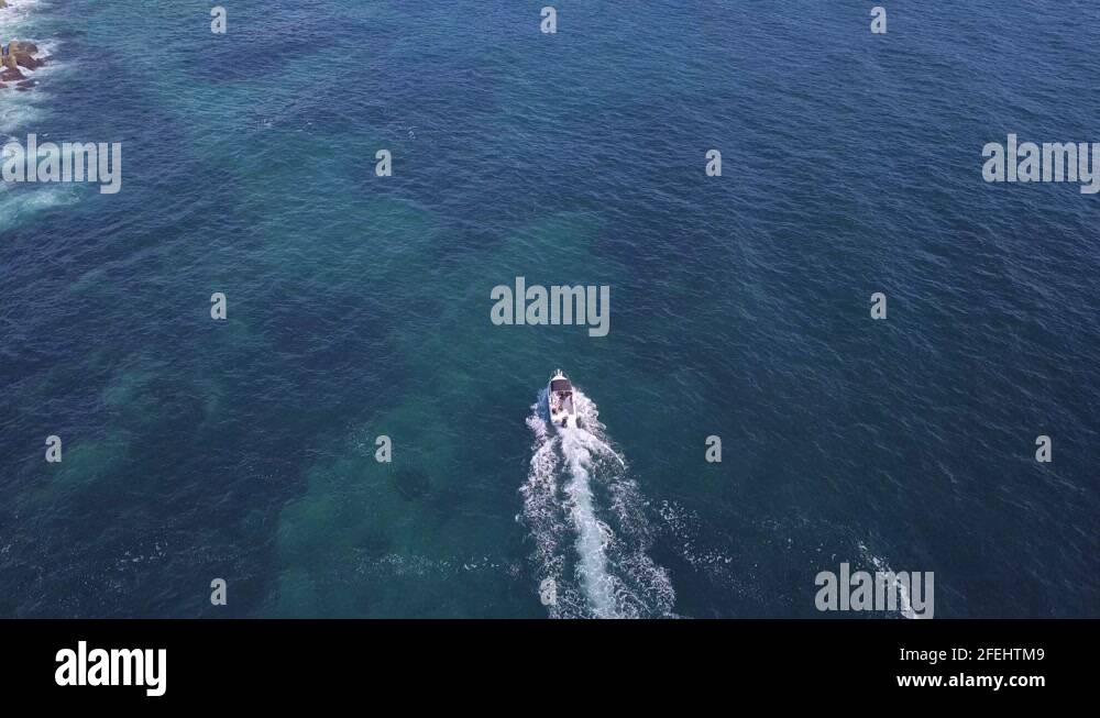Top down overhead view over a fishing boat above the ocean surface at ...
