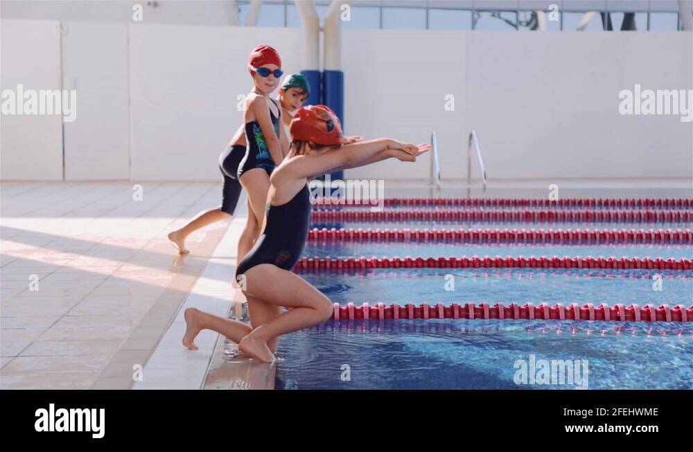 Young Children Diving Into The Swimming Pool One By One. - wide shot ...
