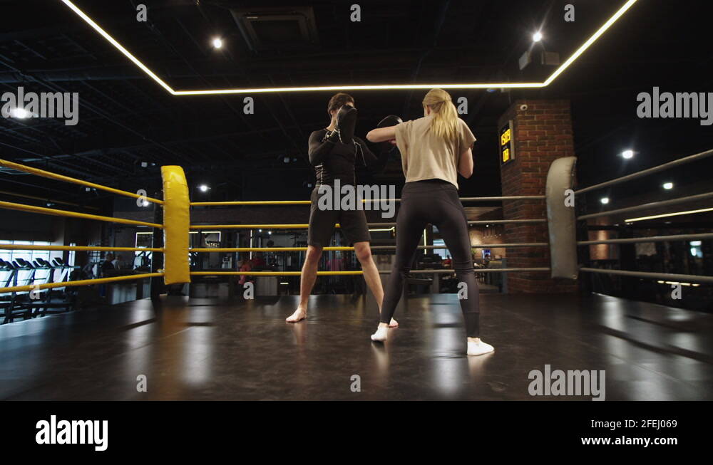 Female boxer training on boxing ring. Fit woman and trainer working out ...