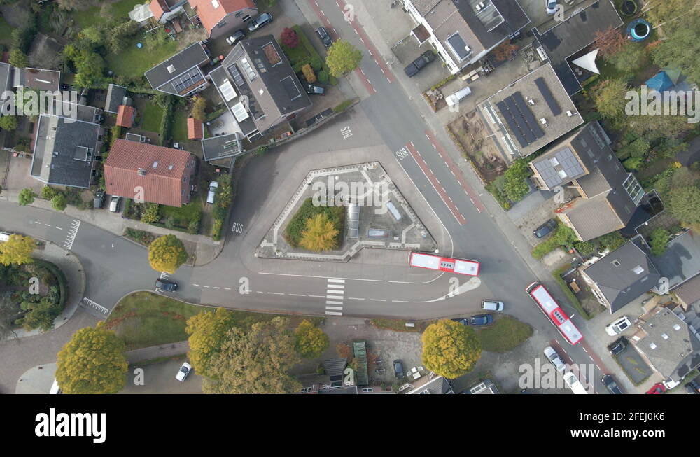 Top down aerial of buses parking at bus stop in green town Stock Video ...