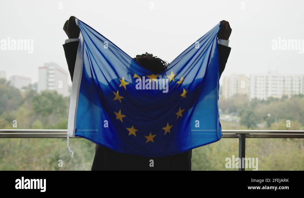 Man Holding And Raising European Flag With High Rise Buildings In The ...