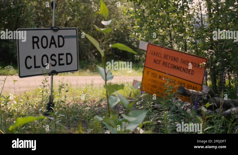 Road signs "ROAD CLOSED" and "Travel beyond this point not recommended ...