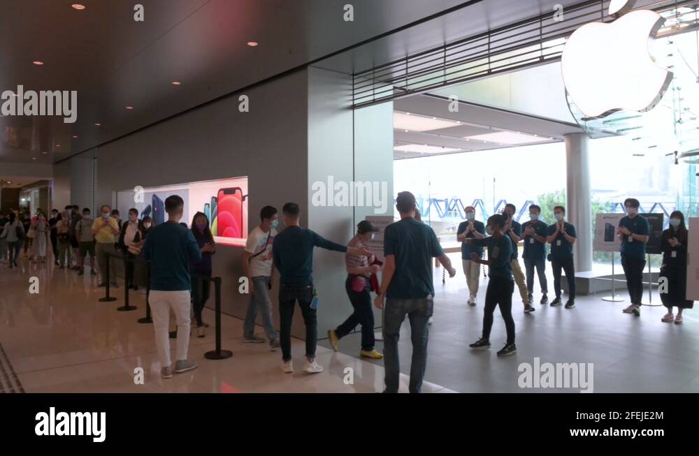 Customers queue in line as the Apple store opens to the public during ...