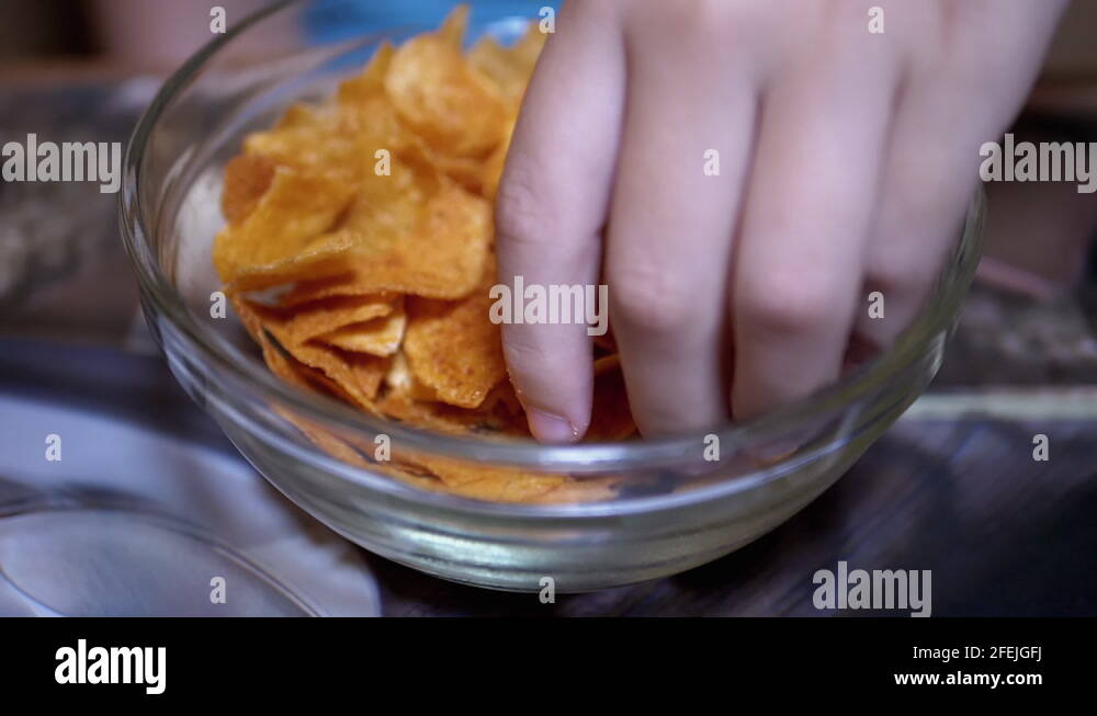 Kid Hand Takes Crispy, Golden Potato Chips, from Plate. Harmful Food ...