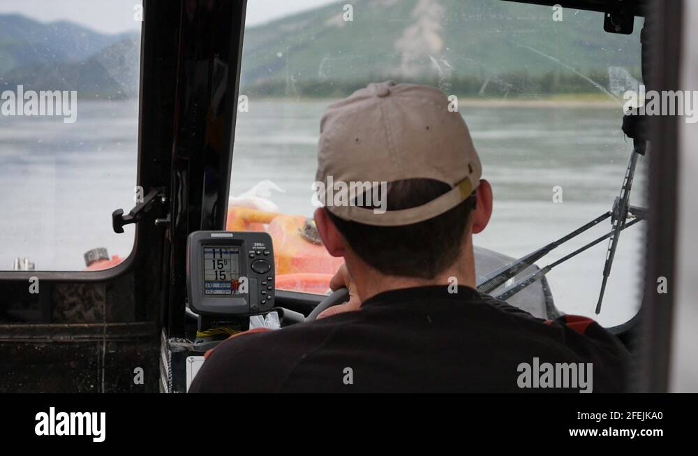 Skipper steering boat, boat cabin shot, back of skipper's head, eye ...