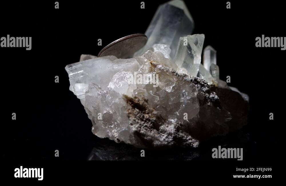 A quartz mineral sample with a dime for size reference. 4k Stock Video ...
