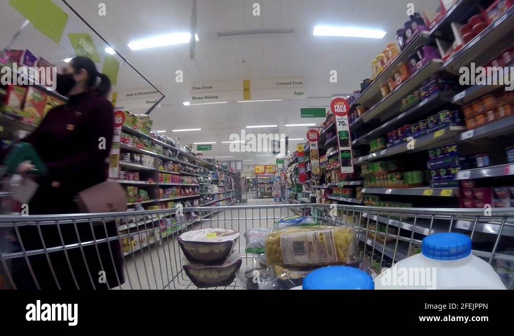 Inside supermarket shopping cart pushing trolley down milk aisle as ...
