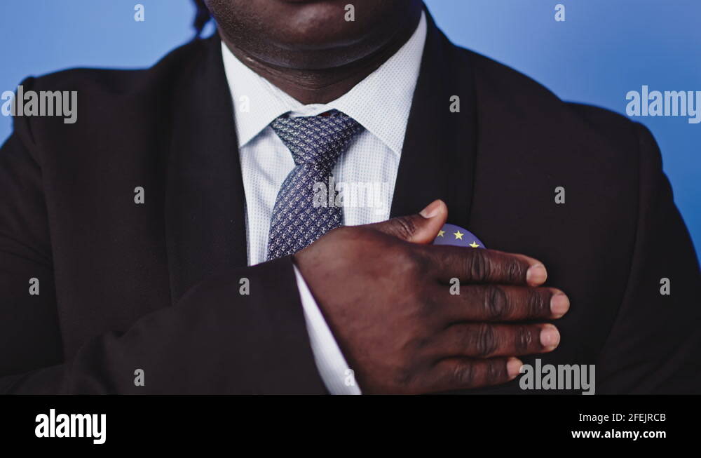 Black man reveals his European Union brooch/pin. Politician man ...