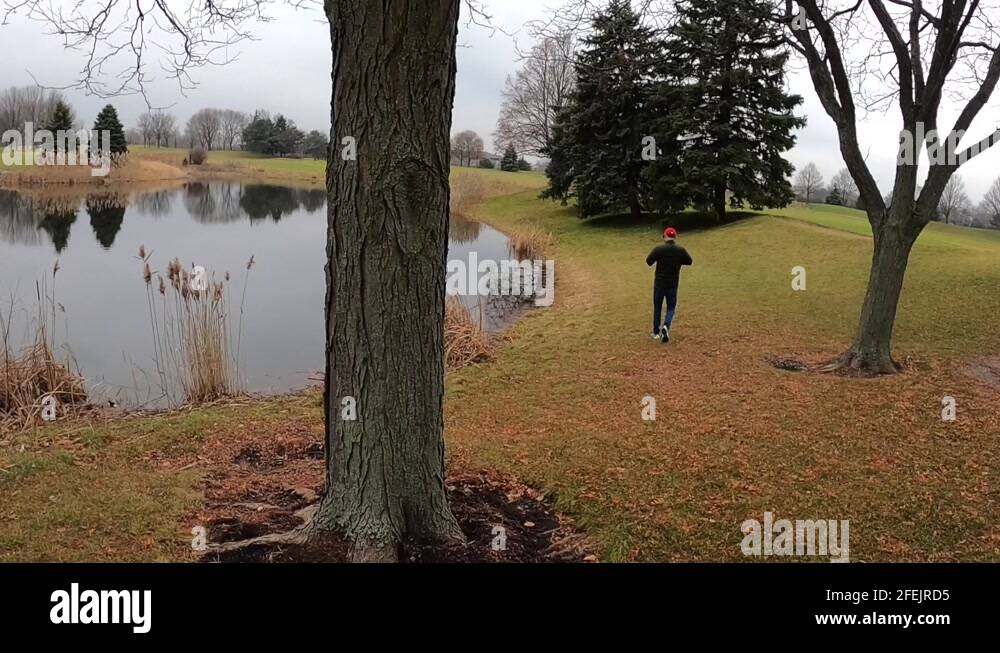 Sad man walking in the park by the lake. Self reflection . Back view ...