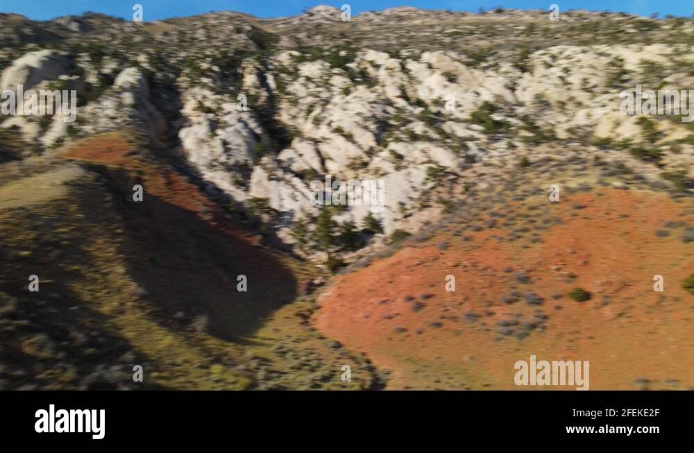 Right pan of a white arid rocky expanse. reveals a white van and water ...