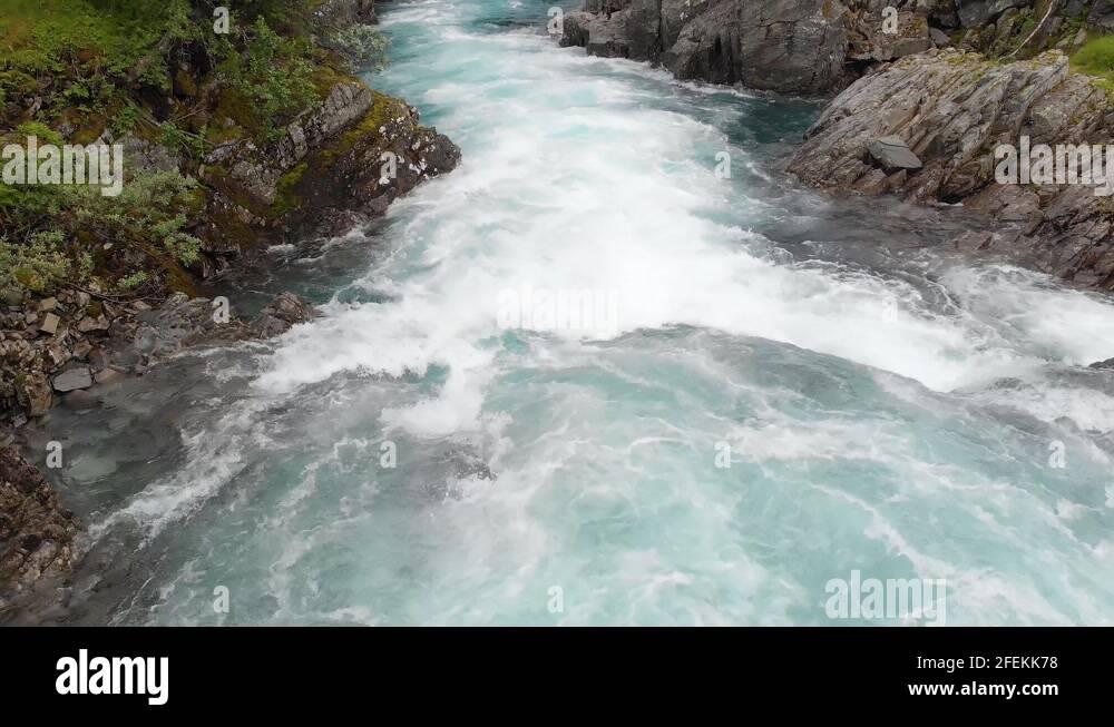 Strong river whitewater rapids flowing down mountainside, aerial reveal ...