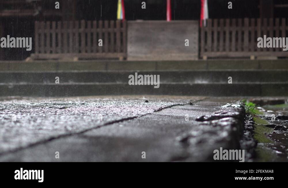 Detail of rain falling on the floor of a Shinto temple in Tokyo. Slow ...