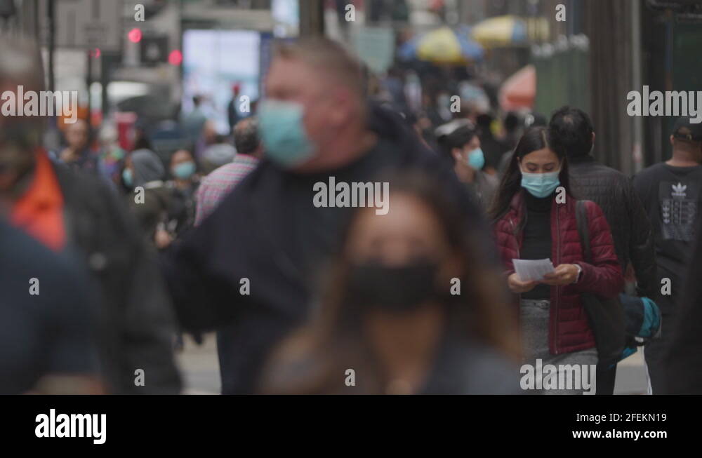 Crowd of people walking street wearing mask masks during coronavirus ...