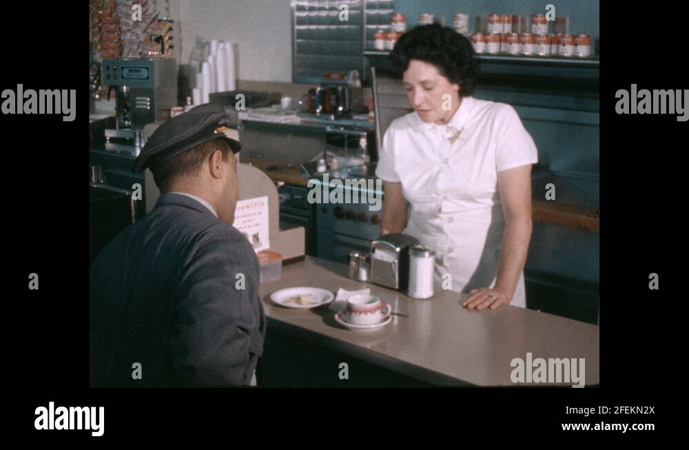 1950s: Woman working behind counter in diner, man pays woman, woman ...