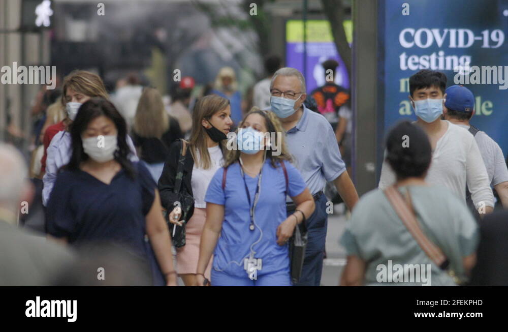 Crowd of people walking street wearing mask masks during coronavirus ...
