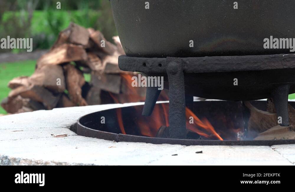 An old fashioned iron kettle over the fire of an outdoor campfire Stock ...